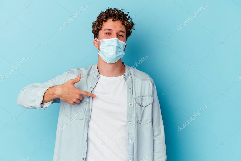 Joven hombre cauc sico con una m scara antiviral aislado en el fondo azul persona se alando a ...