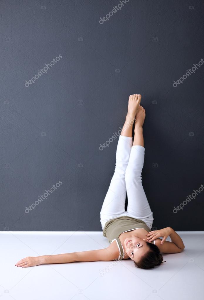 A woman lying on the floor with legs up — Stock Photo © lenetssergey ...