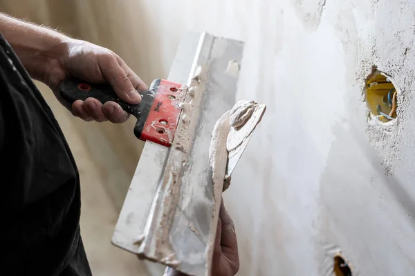 Manual worker with wall plastering tools renovating house. Plasterer ...