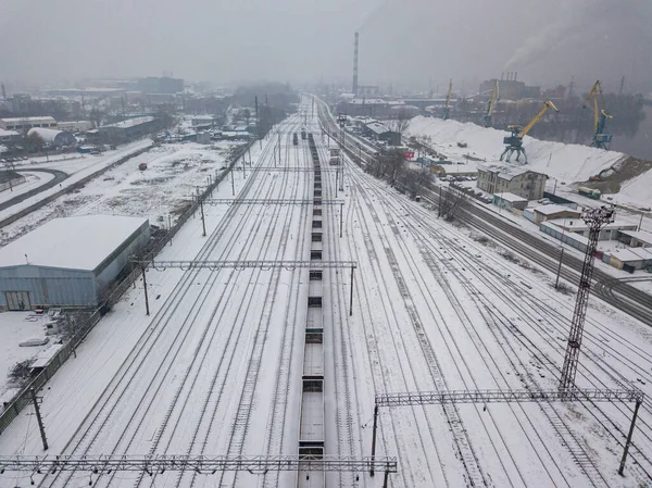 Snow-covered freight train at the station. Snowy day, blizzard. Aerial ...