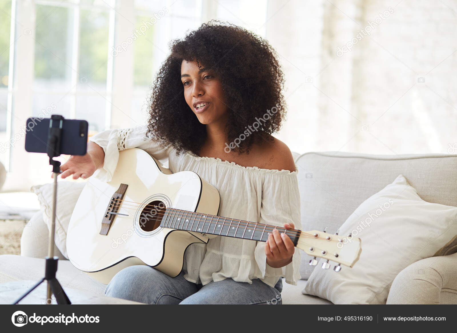 Female black vlogger influencer playing guitar and recording tutorial ...