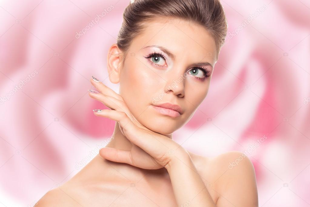 Hermosa cara de mujer joven con piel limpia y fresca aislada en rosa. Retrato de belleza ...