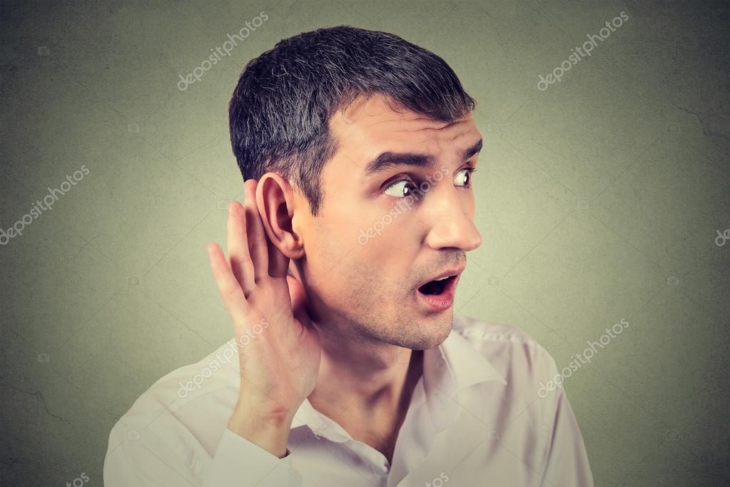 Man placing hand on ear asking someone to speak up or listening ...