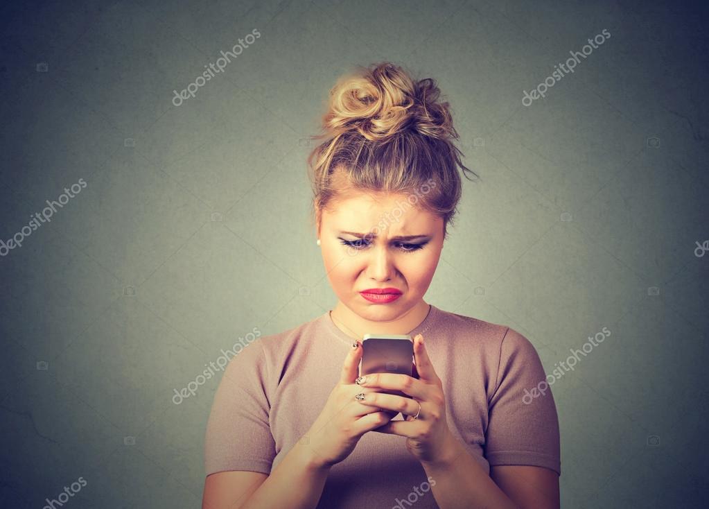 Sad upset woman using mobile phone Stock Photo by ©SIphotography 117341744