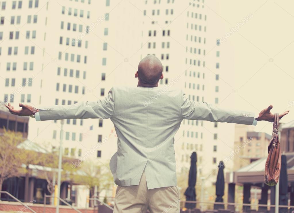 Back view business man celebrates freedom success arms raised looking ...
