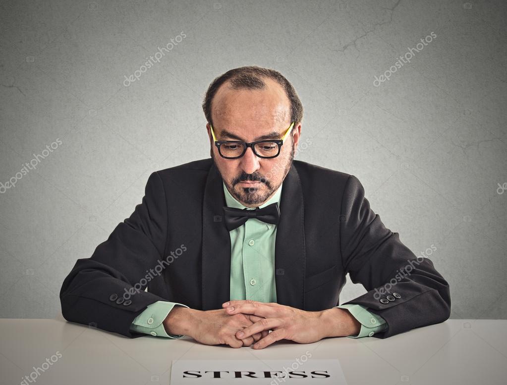 Sad stressed man sitting at office desk Stock Photo by ©SIphotography ...