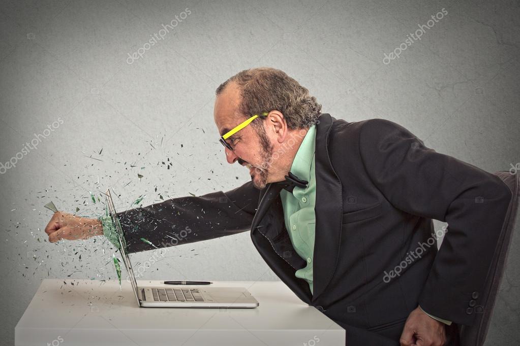 Furious businessman throws a punch into computer — Stock Photo ...