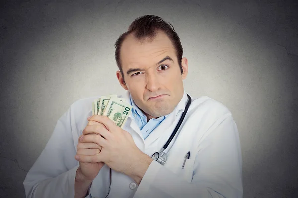 Grumpy greedy miserly health care professional holding money - Stock ...