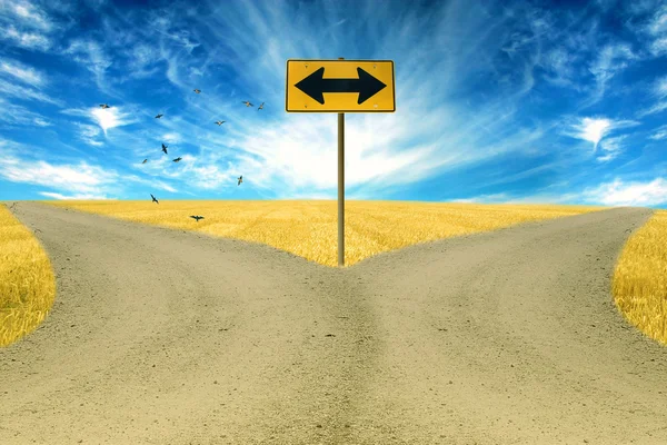 Two roads, road sign ahead with arrows blue sky background - Stock ...