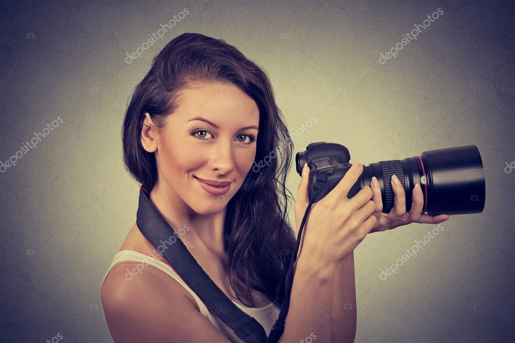 Professional female photographer holding digital camera and smilin ...