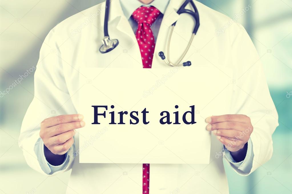 Doctor hands holding white card sign with first aid text message ...