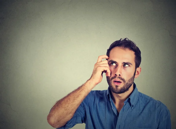 young man scratching head, thinking deeply about something - Stock ...