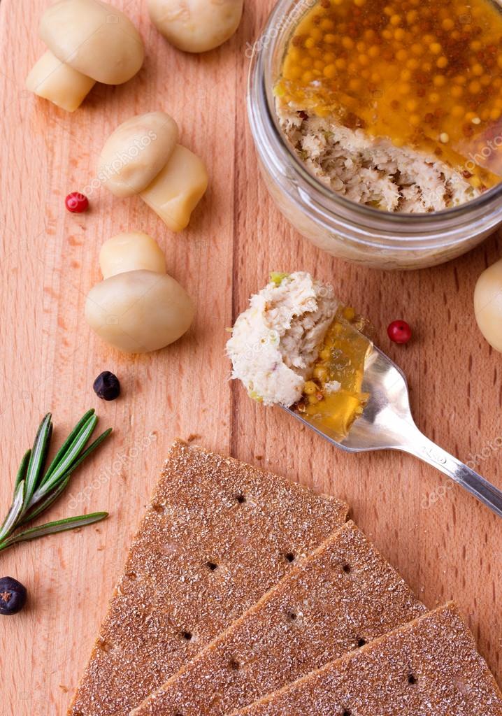 Paté de pollo en frasco y pan crujiente en tabla de cortar madera 2022