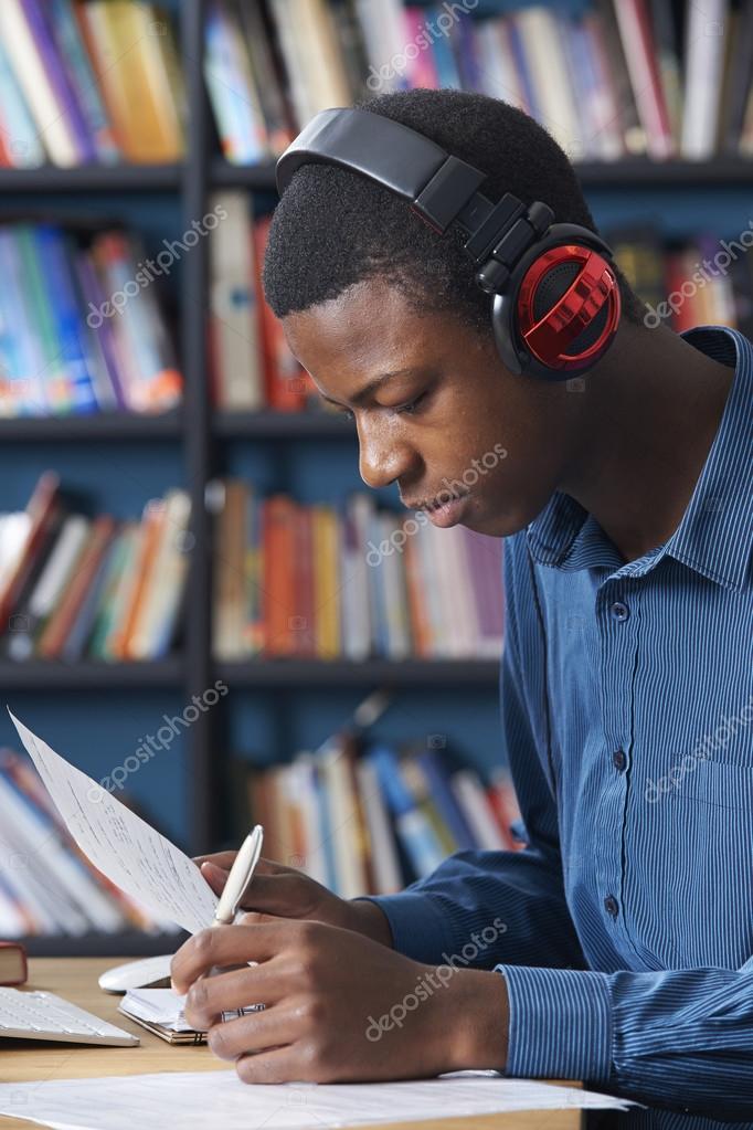 Male Teenage Student Working At Computer Wearing Headphones — Stock ...