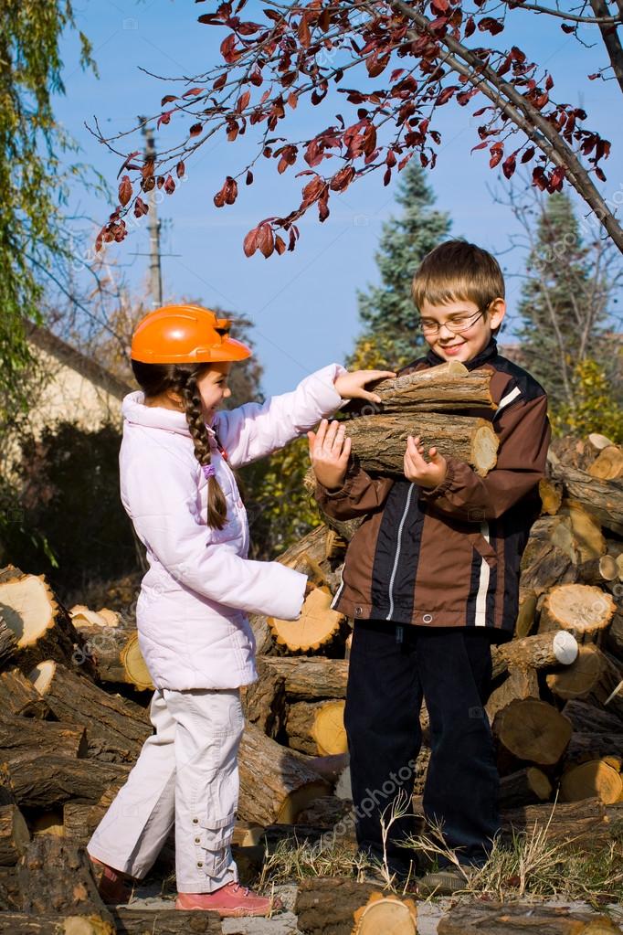 Children helping stack firewood Stock Photo by ©tcsaba 58011733