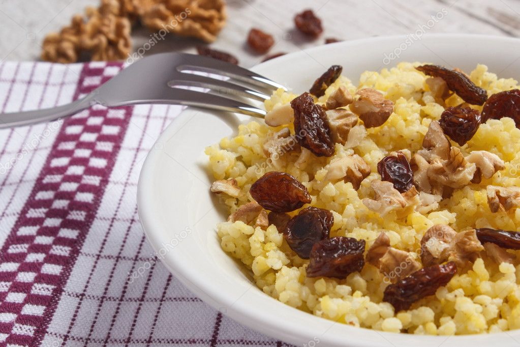 Cooked millet groats with walnuts on white plate, healthy food and ...