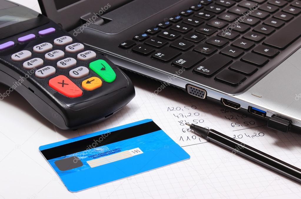 Payment terminal with credit card, laptop and financial calculations ...