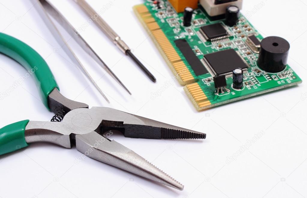 Printed circuit board and precision tools on white background ...