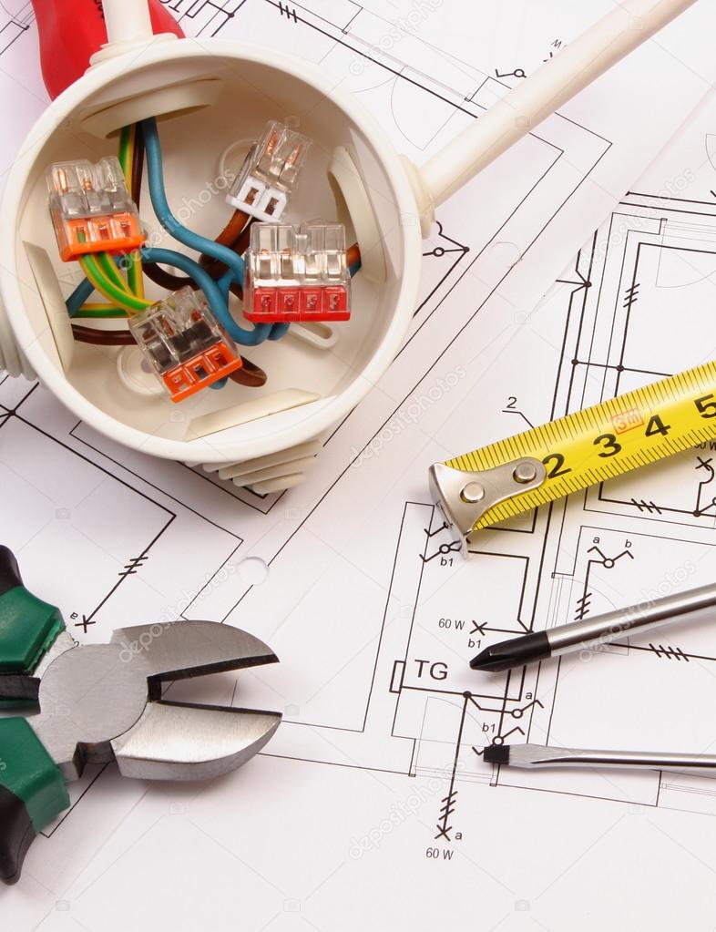 Work tools and electrical box with cables on construction drawing of ...