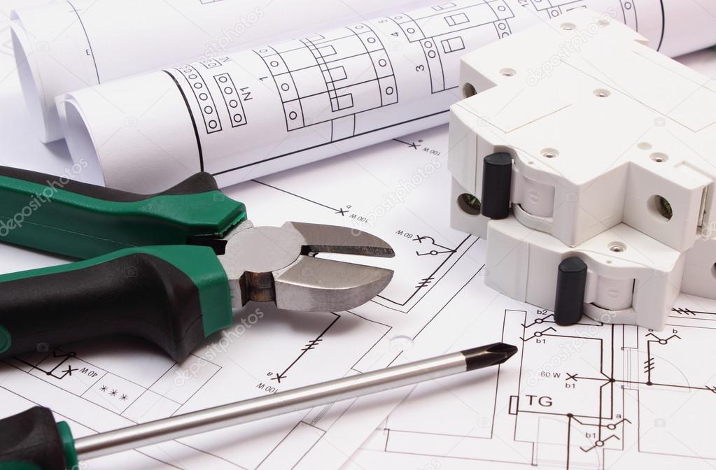 Work tools, electric fuse and rolls of diagrams on construction drawing ...