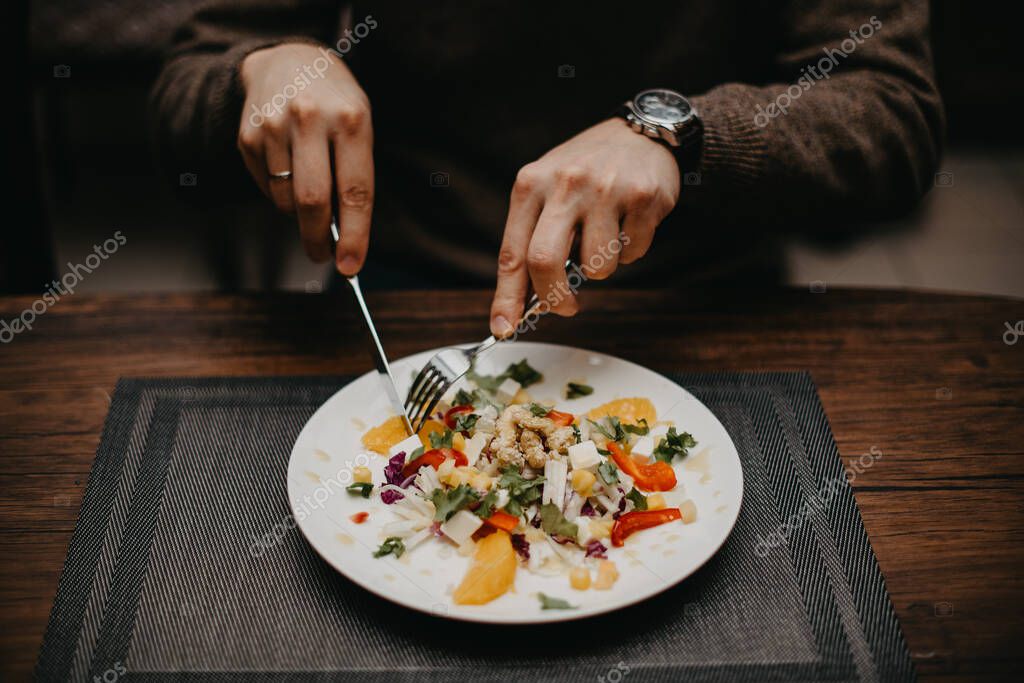 El hombre está almorzando en un restaurante. Comida y vino tinto ...