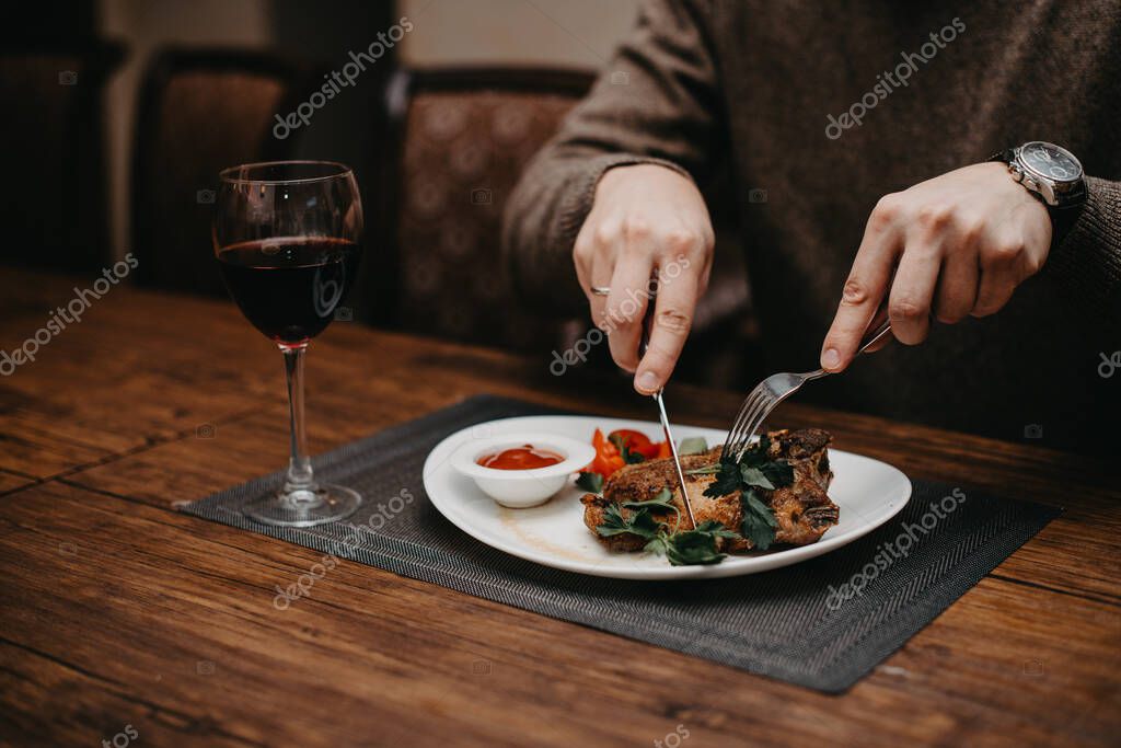 El hombre está almorzando en un restaurante. Comida y vino tinto ...