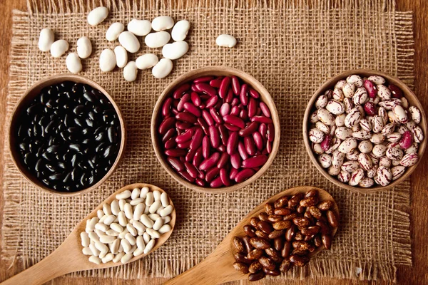 Beautiful multi-colored beans in ceramic bowls on a background of ...