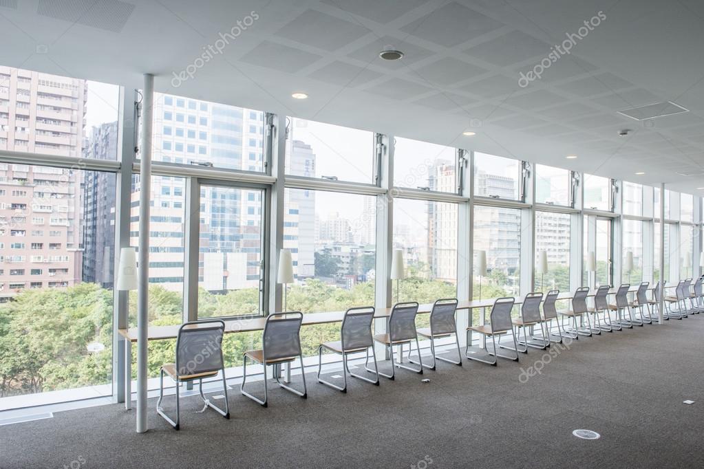 Library interior, with floor to ceiling windows as well as stair chairs ...