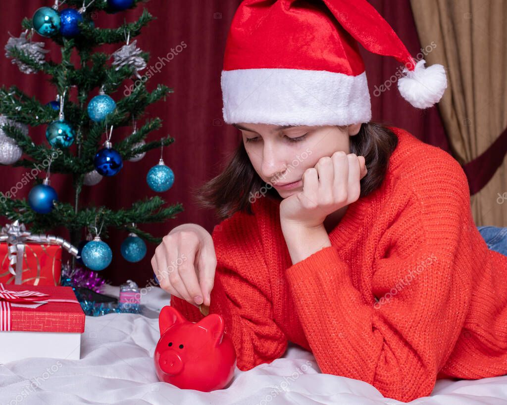 Ahorrar dinero en regalos de Navidad, crisis, concepto pandémico. Chica triste en un sombrero de ...
