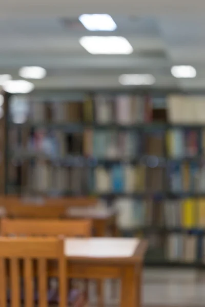 Bookshelf and table desk in library, education abstract blur - Stock ...
