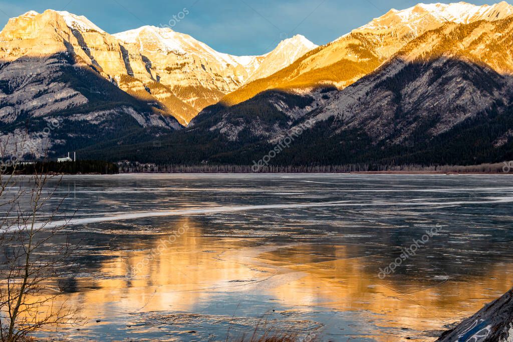 El sol sale sobre el lago y refleja las montañas. Lac de Arc, Alberta ...