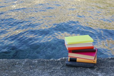 Blurred open book in front with sea and yacht in the background. Relax ...