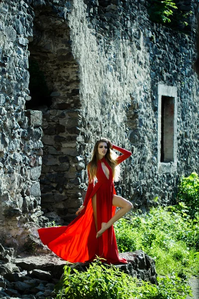 Sexy woman in red dress in ruins Stock Photo by ©Tverdohlib.com 182135392