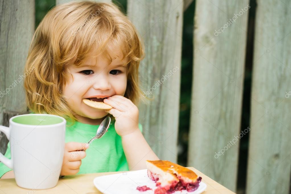 Small boy eating pie near wooden fence — Stock Photo © Tverdohlib.com ...