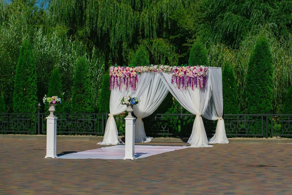 Lilac wedding arch with flowers on ceremony place Stock Photo by ...