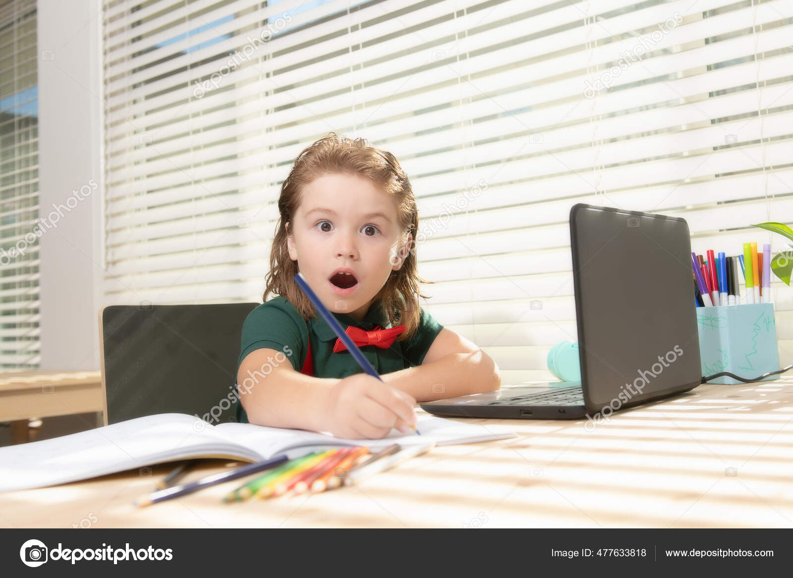 Étonnant écolier écrivant au carnet de notes en classe à l'école ...