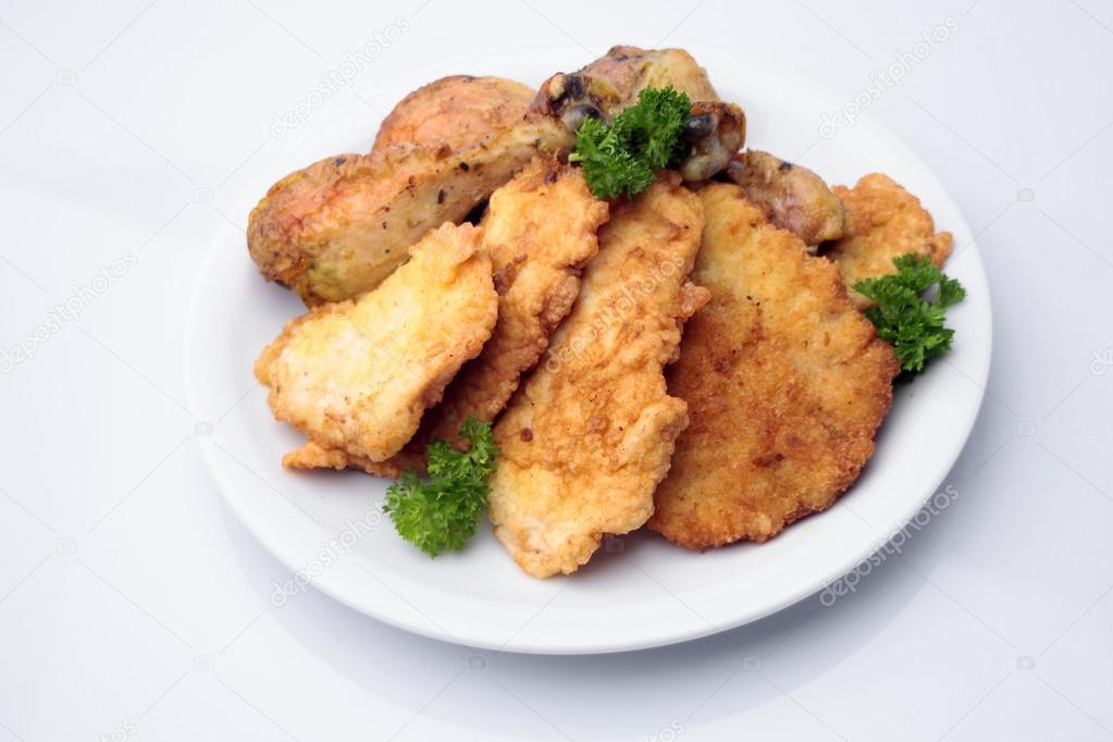 Chuletas de cerdo empanadas y patas de pollo en el plato 2022