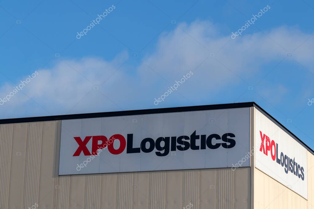 Logo XPO Logistics rojo y negro sobre fondo blanco en almacén 2024