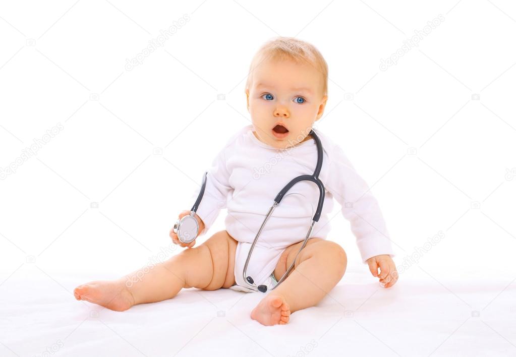 Baby playing with stethoscope sitting on white background Stock Photo ...
