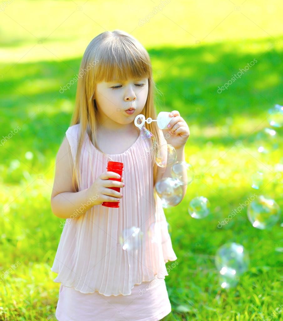 Child blowing soap bubbles outdoors in sunny summer day — Stock Photo ... Child blowing soap bubbles outdoors in sunny summer day — Stock Photo ...