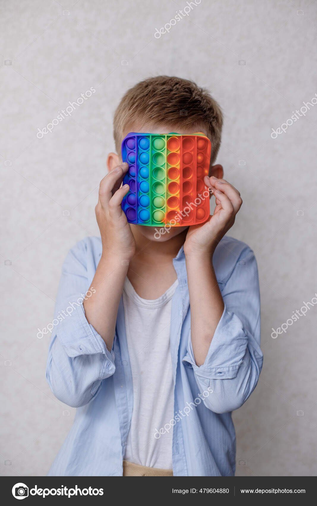 The boy shows Pop It. Flexible tactile toy with anti-stress push bubble ...