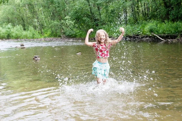 A little girl swims in the river. — Stock Photo © Tsomkaigor #27830199