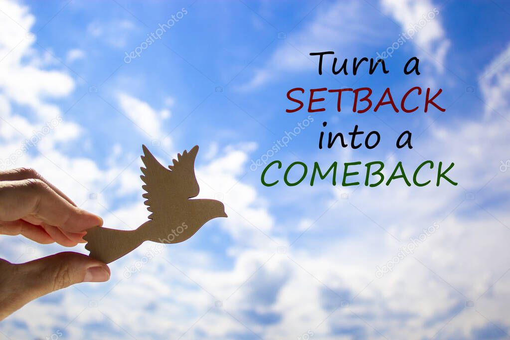 Setback or comeback symbol. Man hand holding wooden bird on cloud sky ...