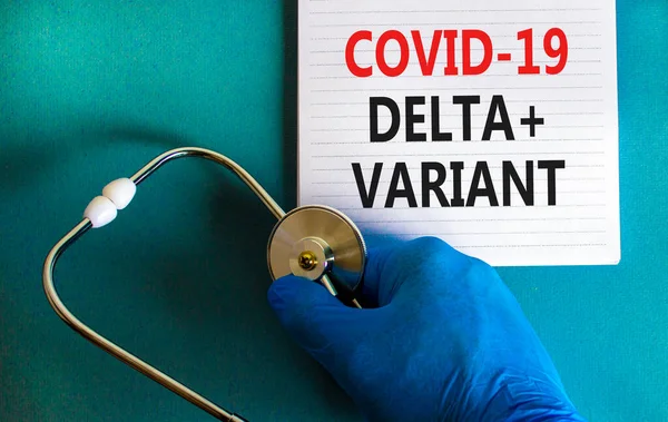 Covid-19 delta plus variant strain symbol. Mano de doctor en guante azul, tarjeta blanca ...