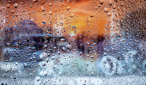 City view through a window on a rainy night,Rain drops on window with ...