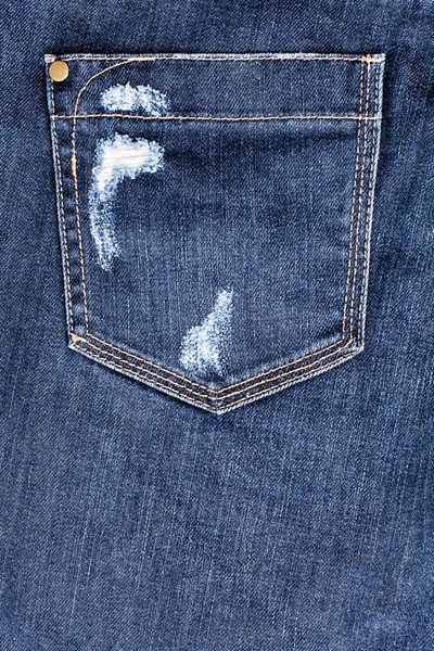 Blue worn jeans pocket close up, ripped jeans pocket background, dark blue damaged denim ...