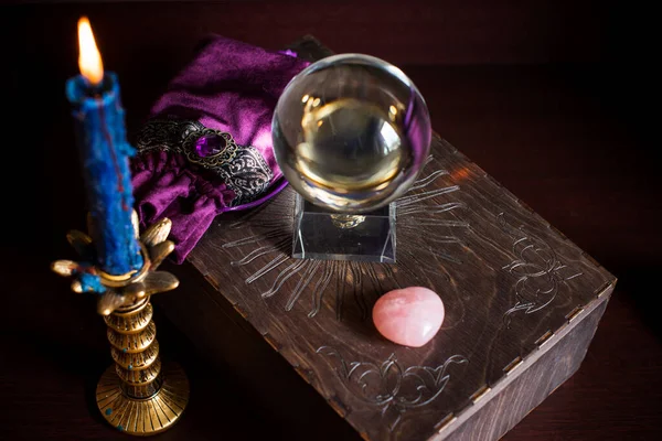 A fortune teller, witch stuff on a table, candles and fortune-telling ...