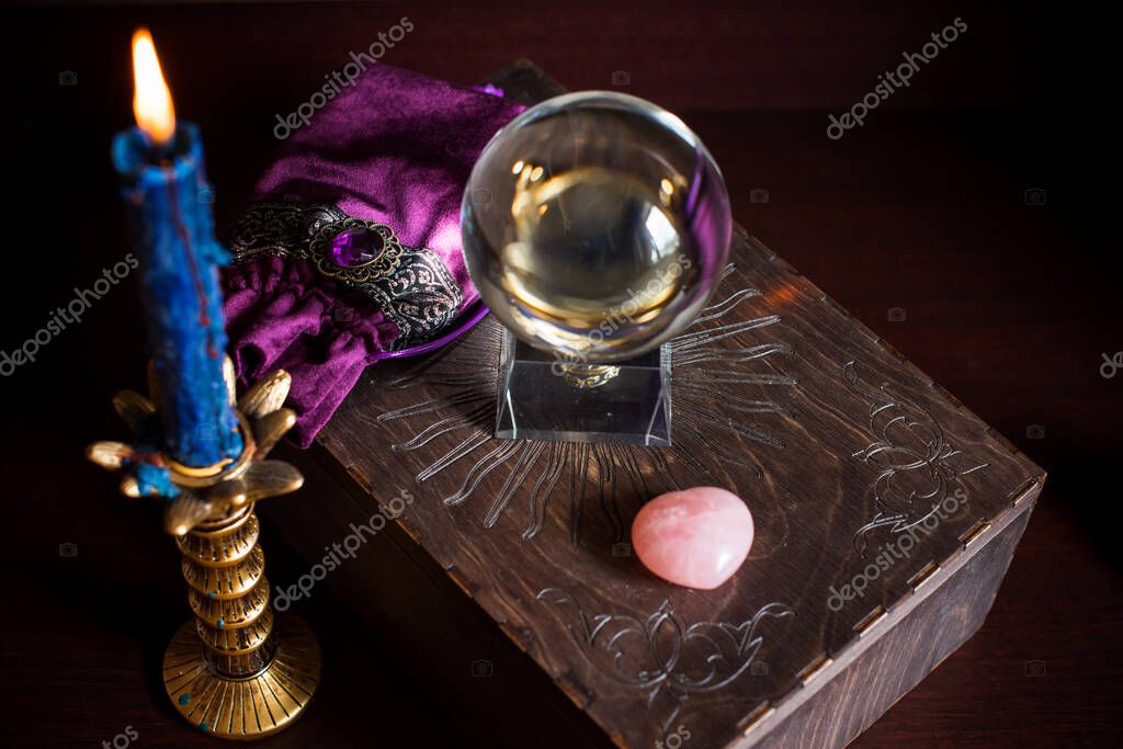 Una adivina, cosas de brujas en una mesa, velas y objetos adivinos. El ...
