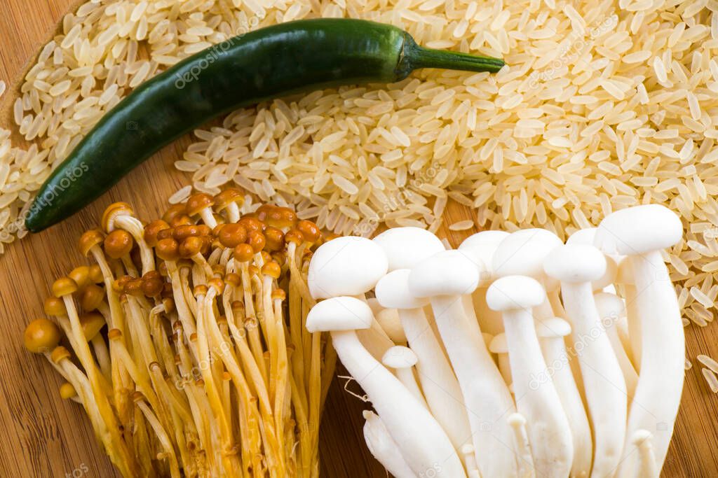 Hongos Enoki asiáticos de color marrón dorado y blanco, fondo vegetal ...