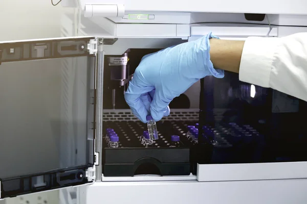 Research scientist hand with gloves holding vial (small bottle) to put ...